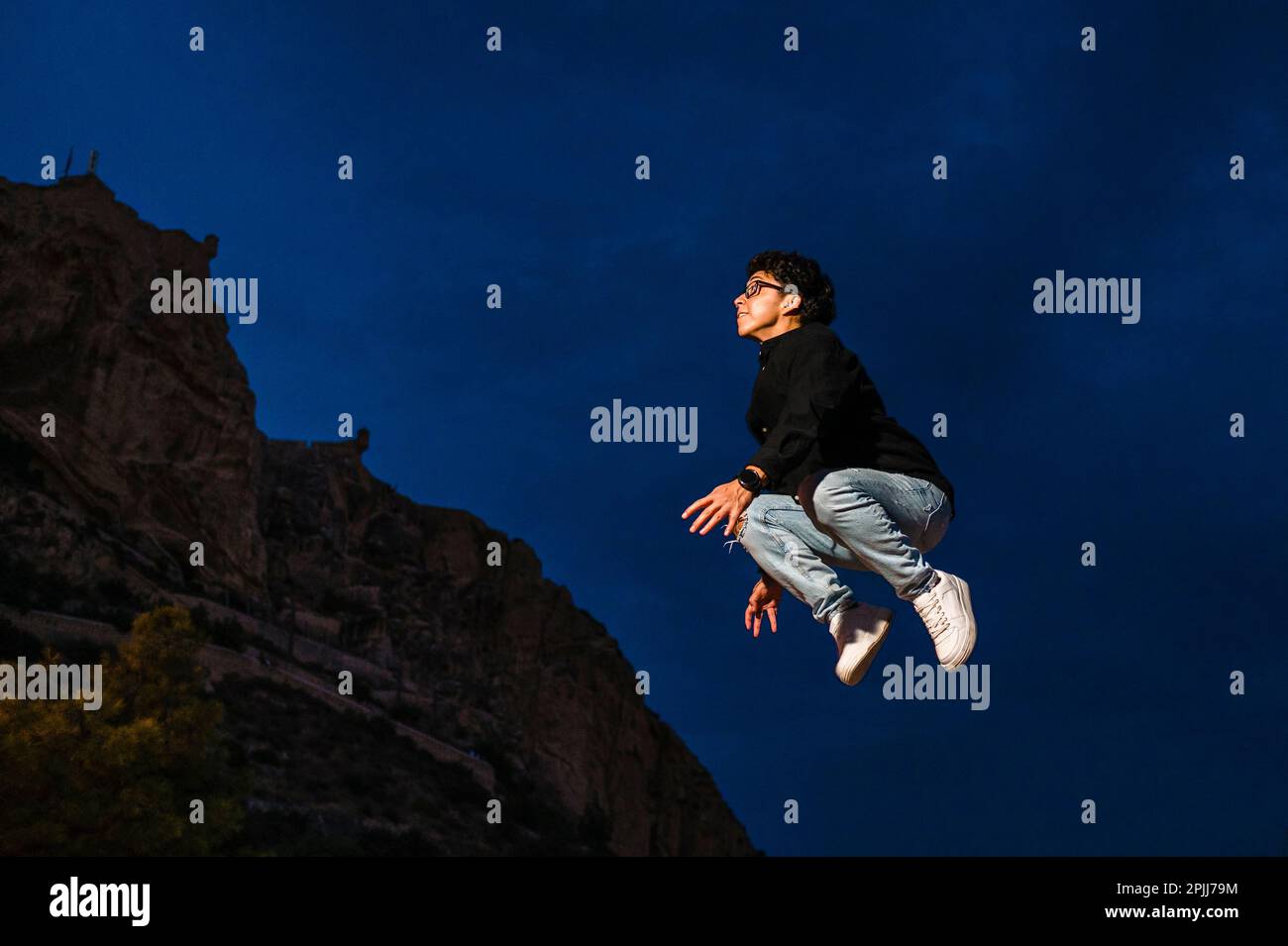 Young transgender man jumping outdoors at night Stock Photo - Alamy