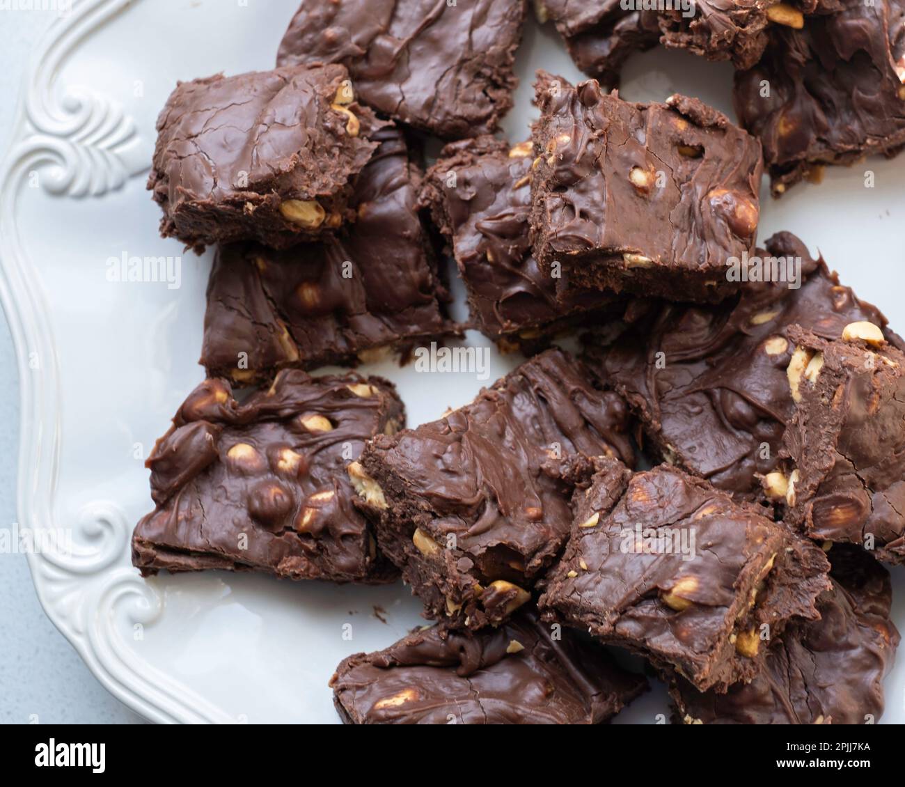 Homemade peanut chocolate fudge squares on a white plate, white ...