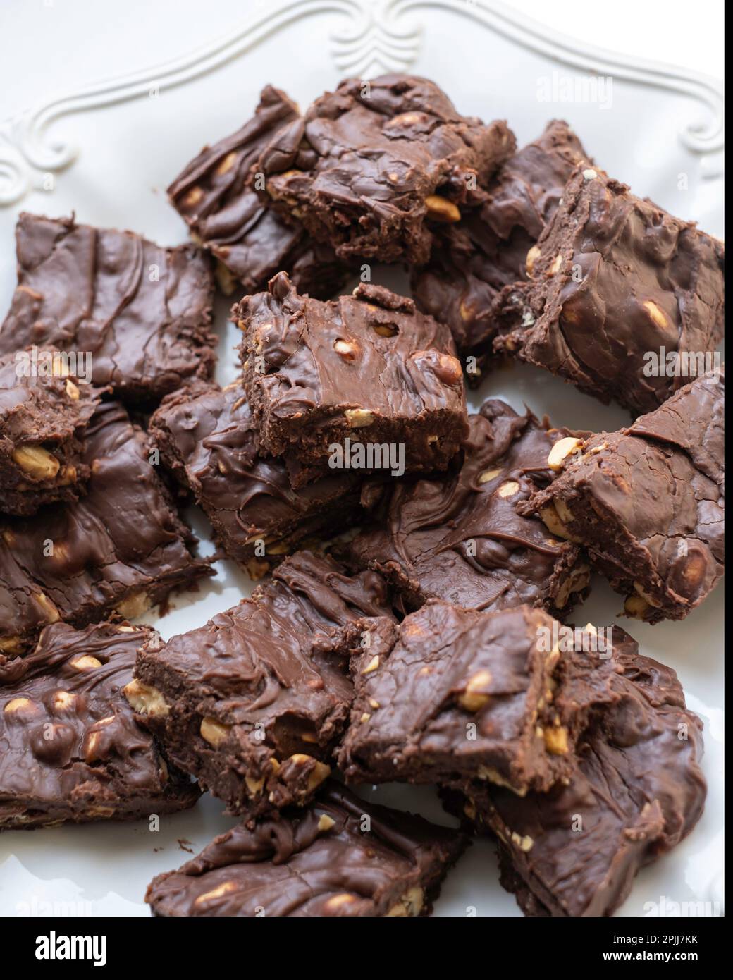 Homemade peanut chocolate fudge squares on a white plate, white ...