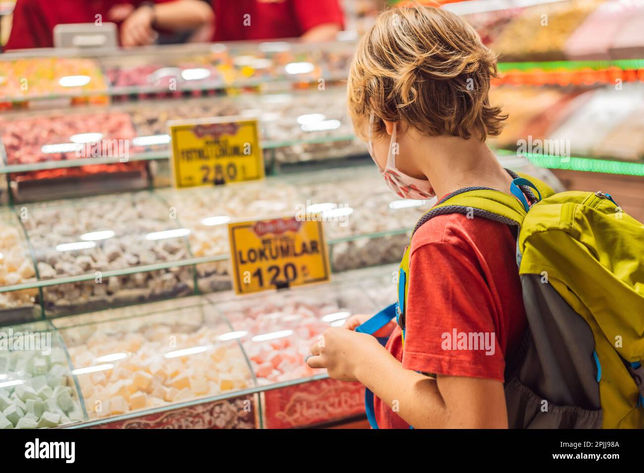 The boy looks at the counter with Turkish sweets. Traditional oriental ...