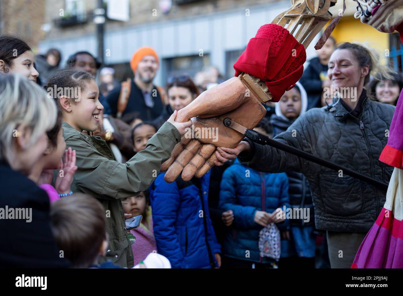 London, UK. 02nd Apr, 2023. Little Amal shakes hands with children ...