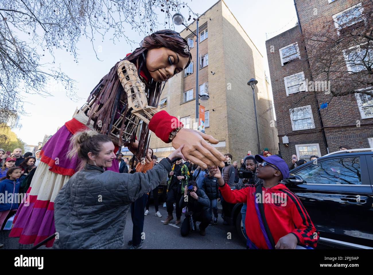 London, UK. 02nd Apr, 2023. Little Amal shakes hands with a child ...
