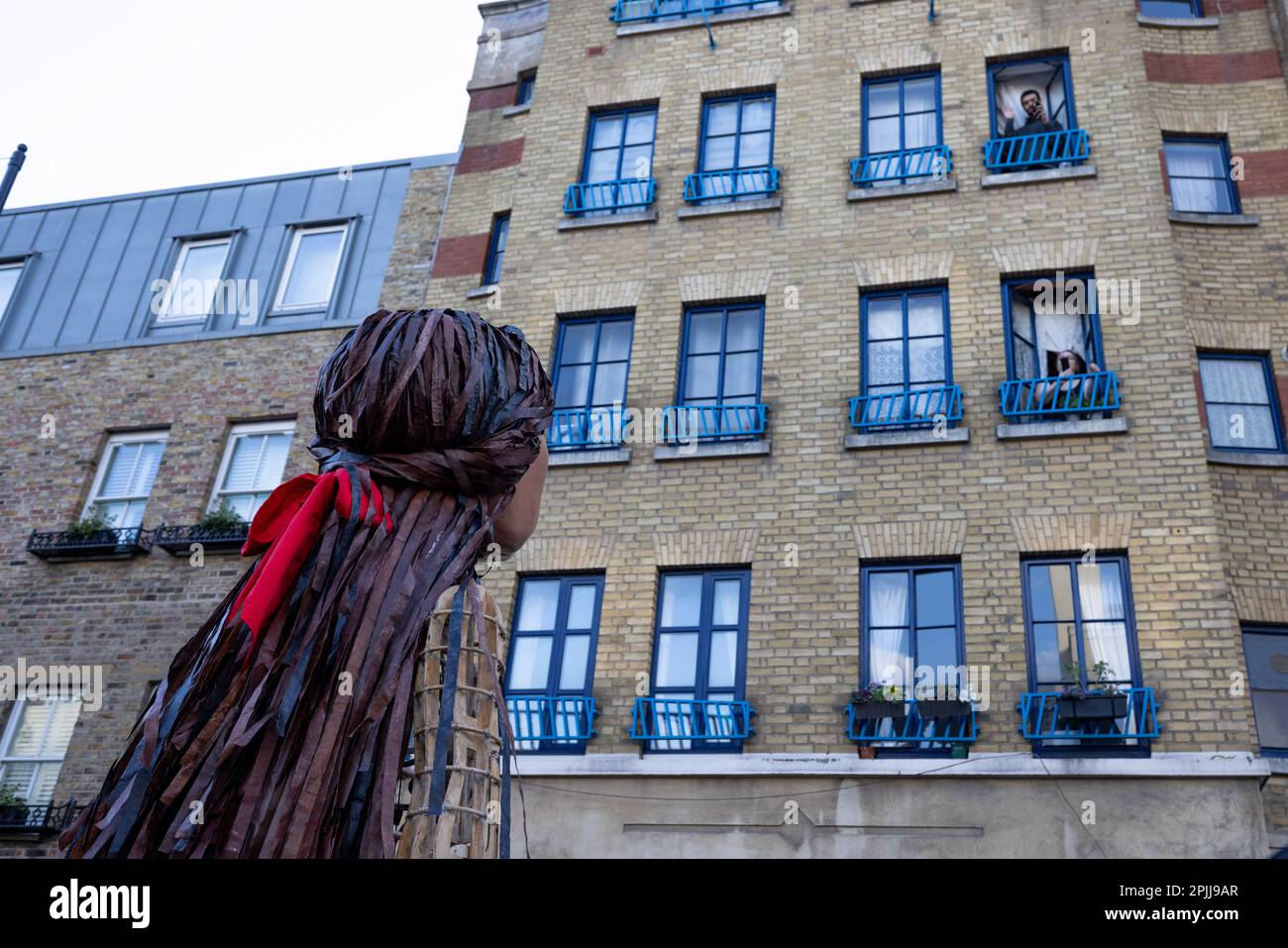 London, UK. 02nd Apr, 2023. Little Amal looks up at the residents who ...