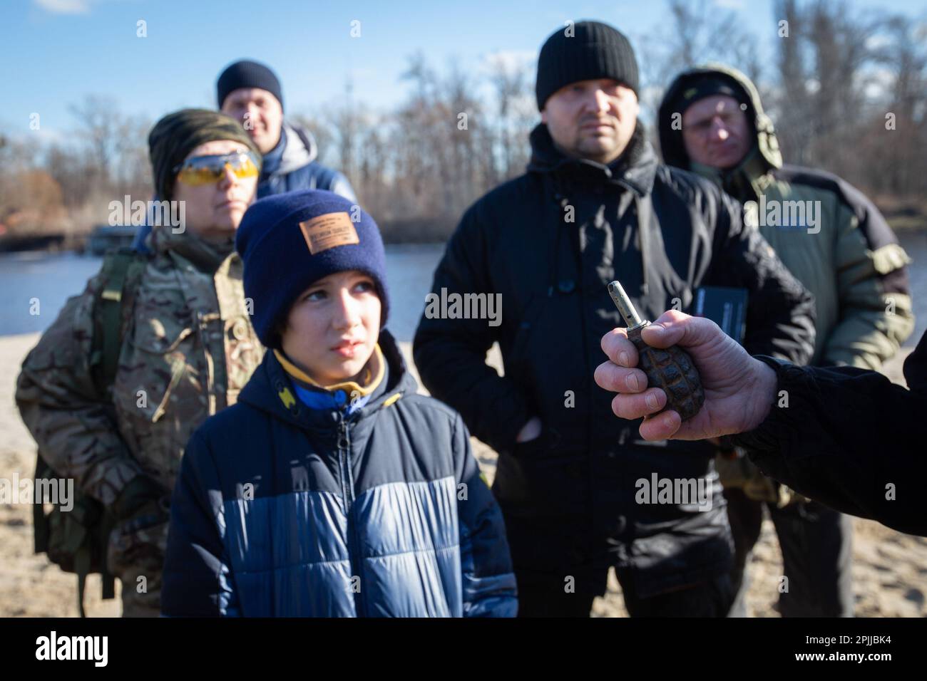 A territorial defense fighter demonstrates a training hand grenade ...