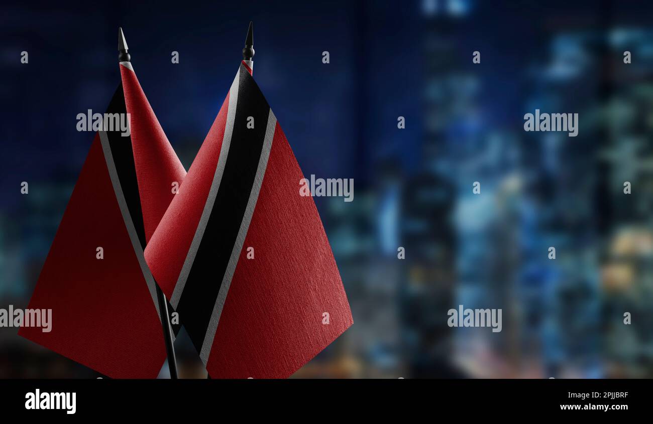 Small flags of the Trinidad and Tobago on an abstract blurry background ...