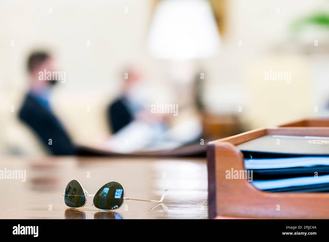 President Biden's sunglasses are seen on the Resolute Desk during an ...
