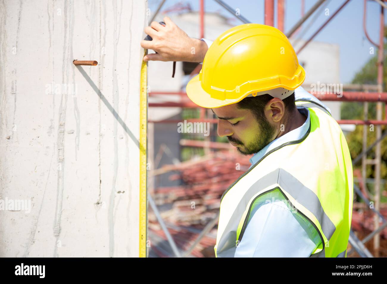 Engineer young man using tape measure for check and examining length of ...