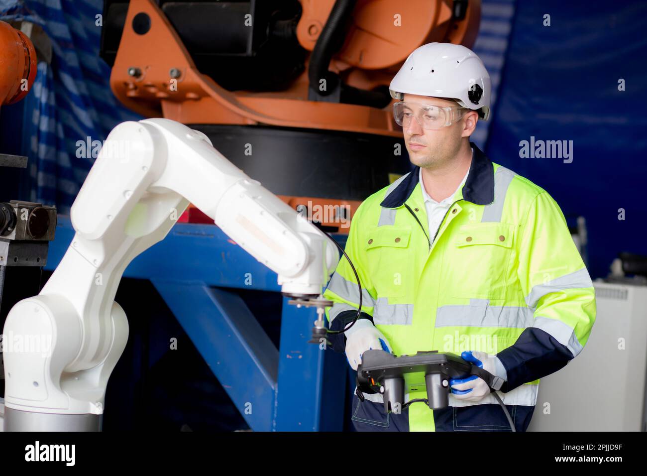Young engineer man checking and maintenance machine robot arms ...
