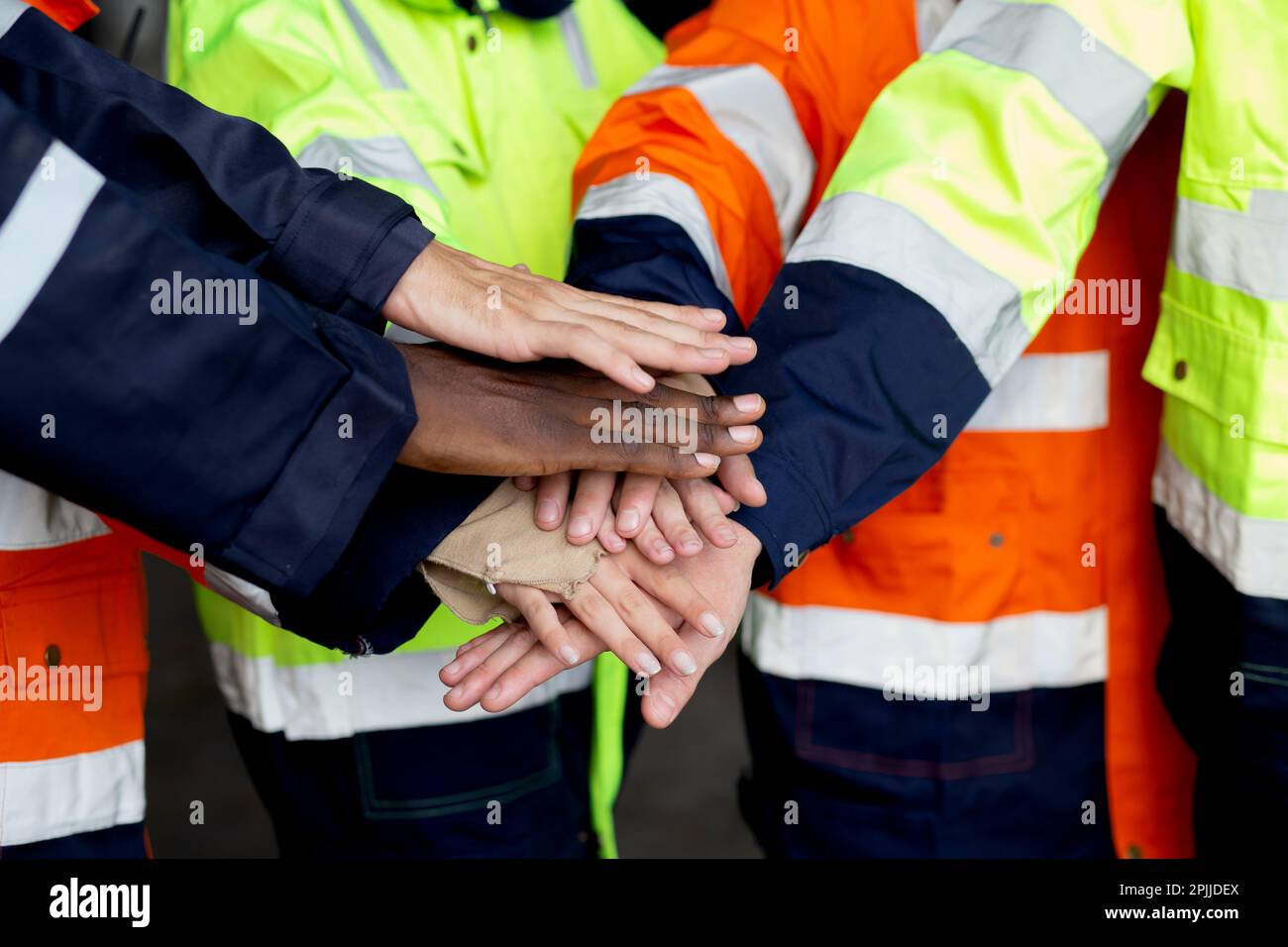 Closeup group of engineer team harmonious with hands stack for goal and ...