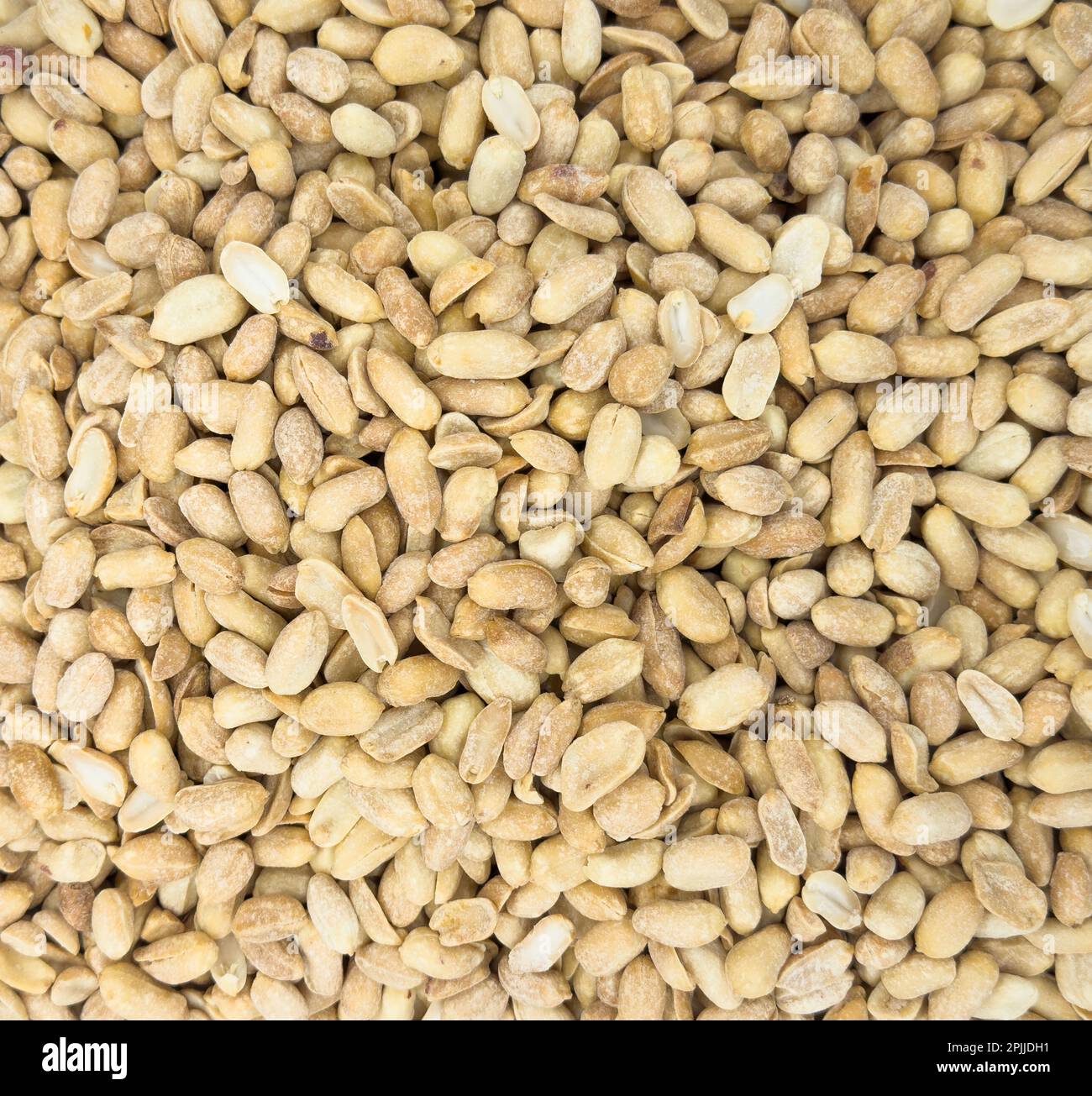 Roasted unpeeled peanuts macro shot. Peanuts as a background. A lot of ...