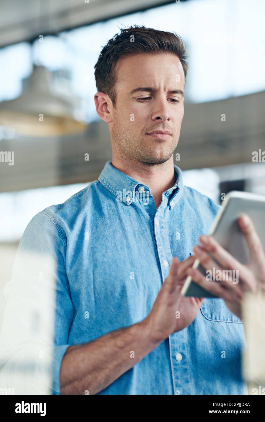 Figuring out all the features. a handsome young businessman using his ...