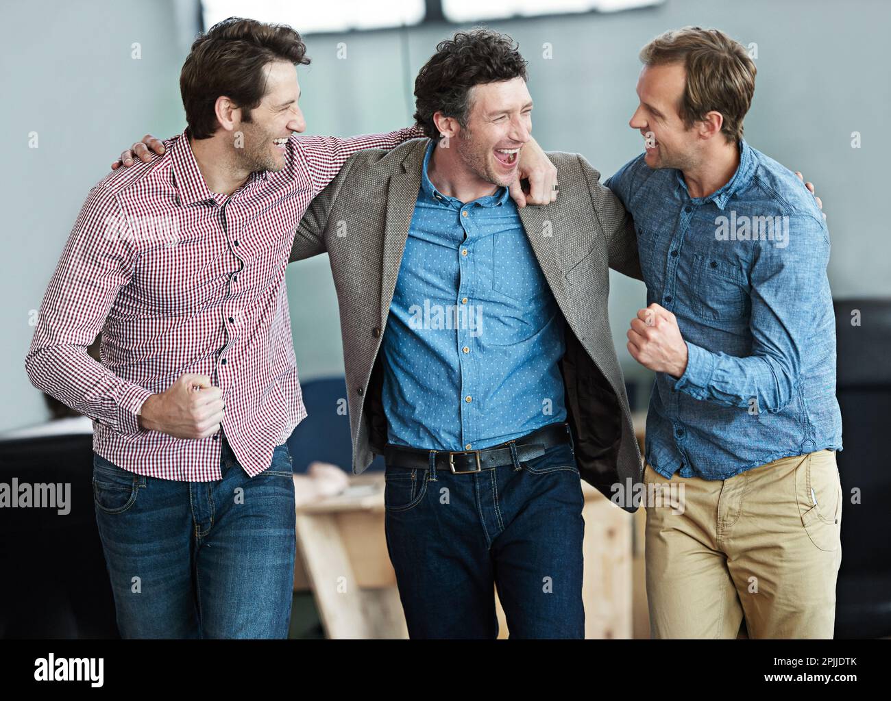 Go teamwork. a group of happy male colleagues celebrating arm in arm in ...