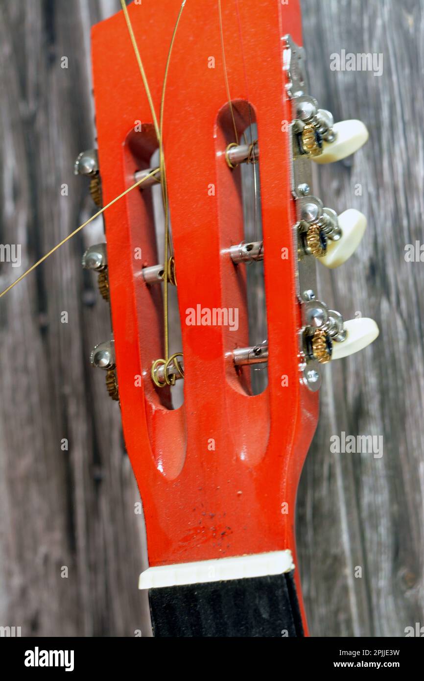 A broken wooden old classic guitar with damaged strings chords ...