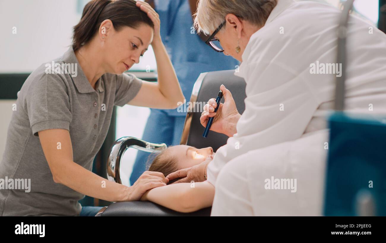 Diverse medical team consulting little girl being unconscious, using ...