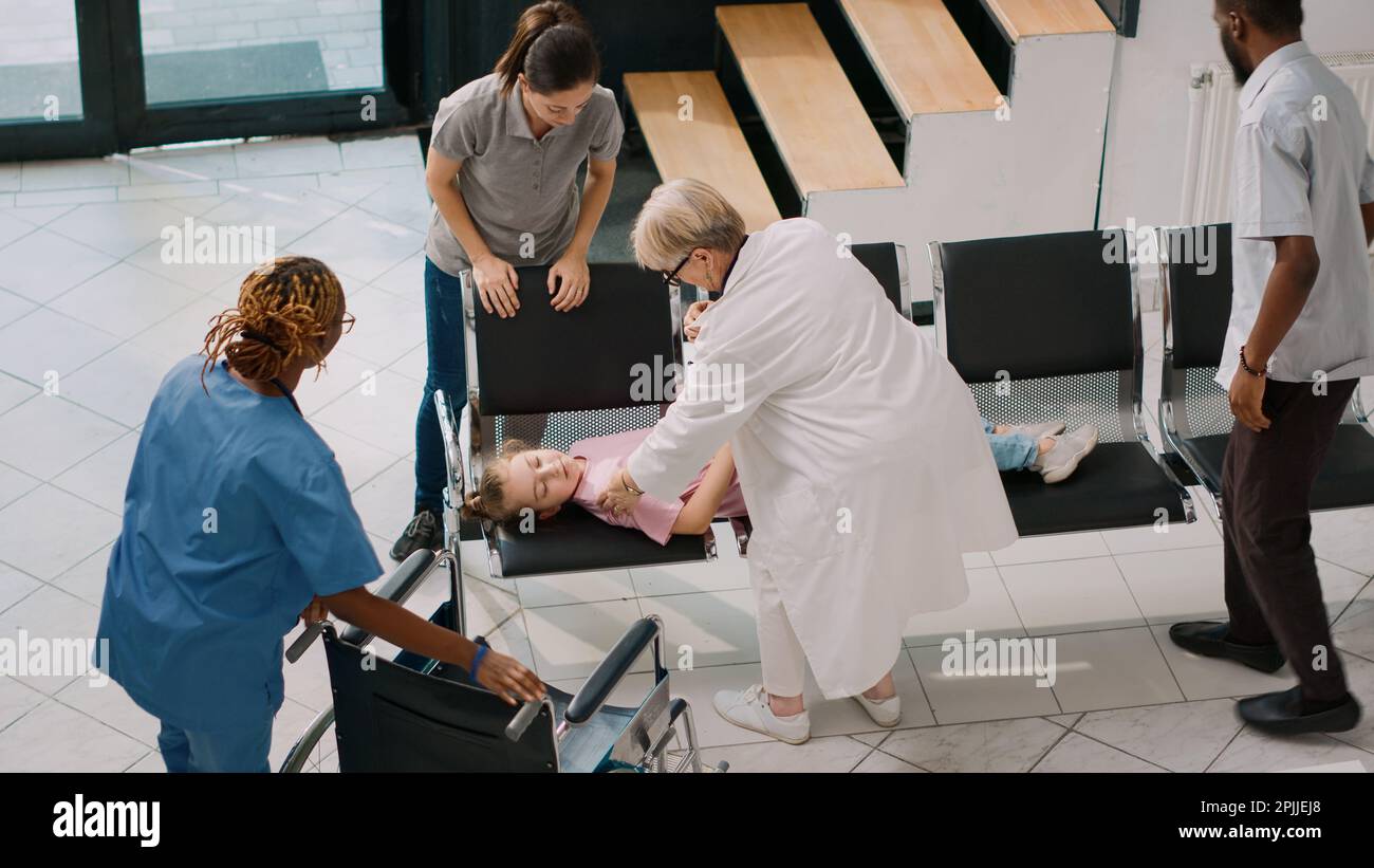 Worried man bringing unconscious girl in hospital lobby, kid fainting ...