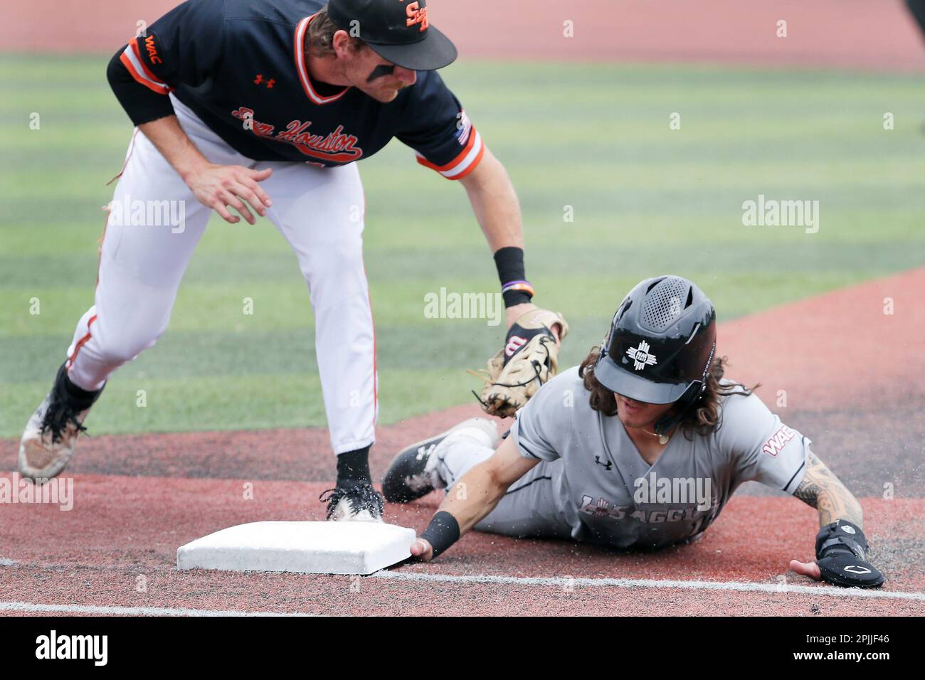 New Mexico State runner Romeo Ballesteros, right, is safe on a return ...