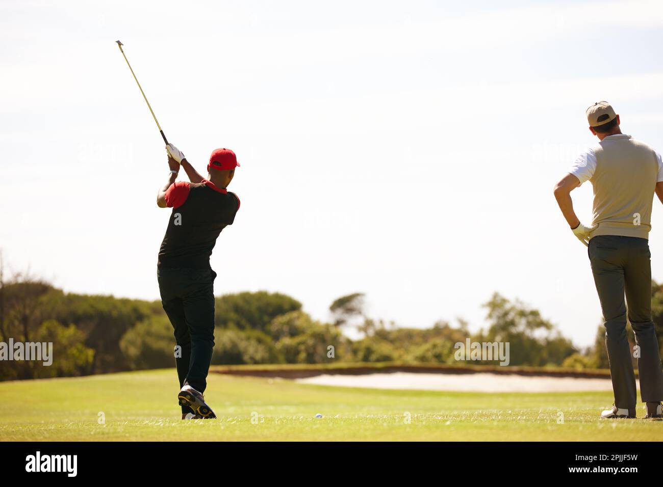 Its all in the swing. two handsome men playing a game of golf Stock ...