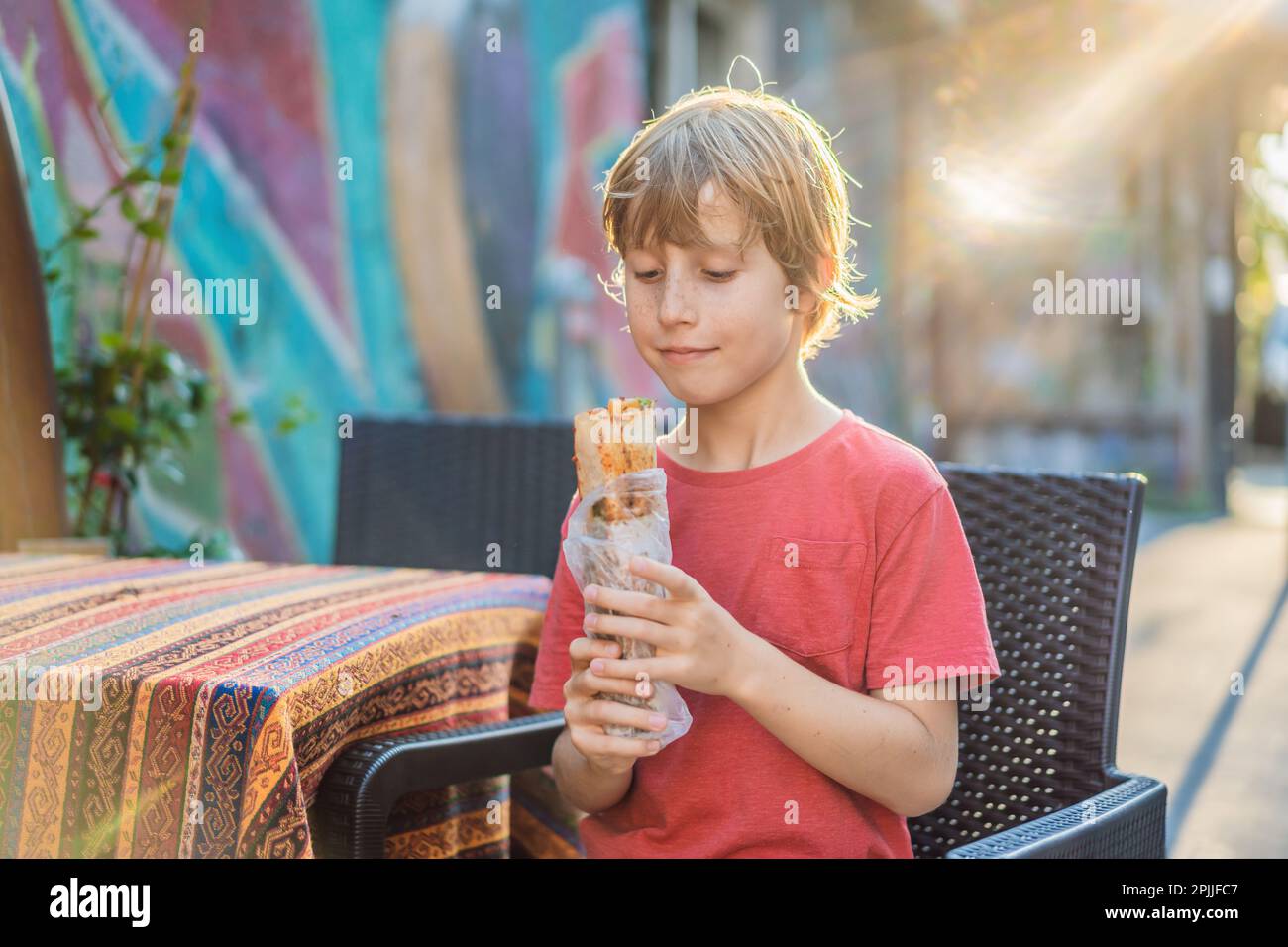 Boy eating street food in Istanbul. Balik ekmek - fish in a bread ...