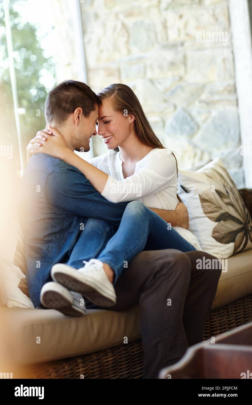 We could do this all day. A young couple cuddling on a couch indoors ...