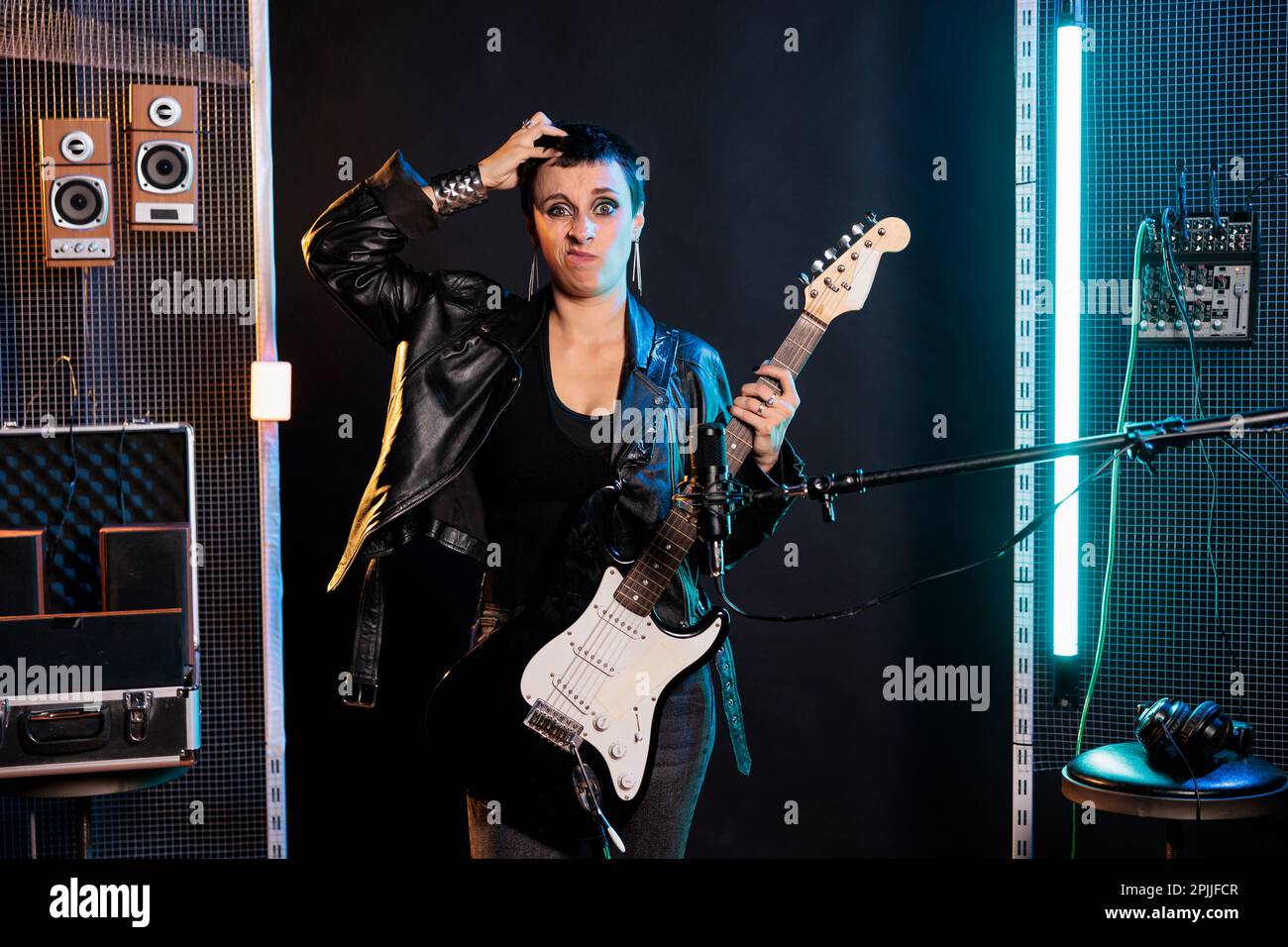 Confused singer having uncertain expression while playing electric ...