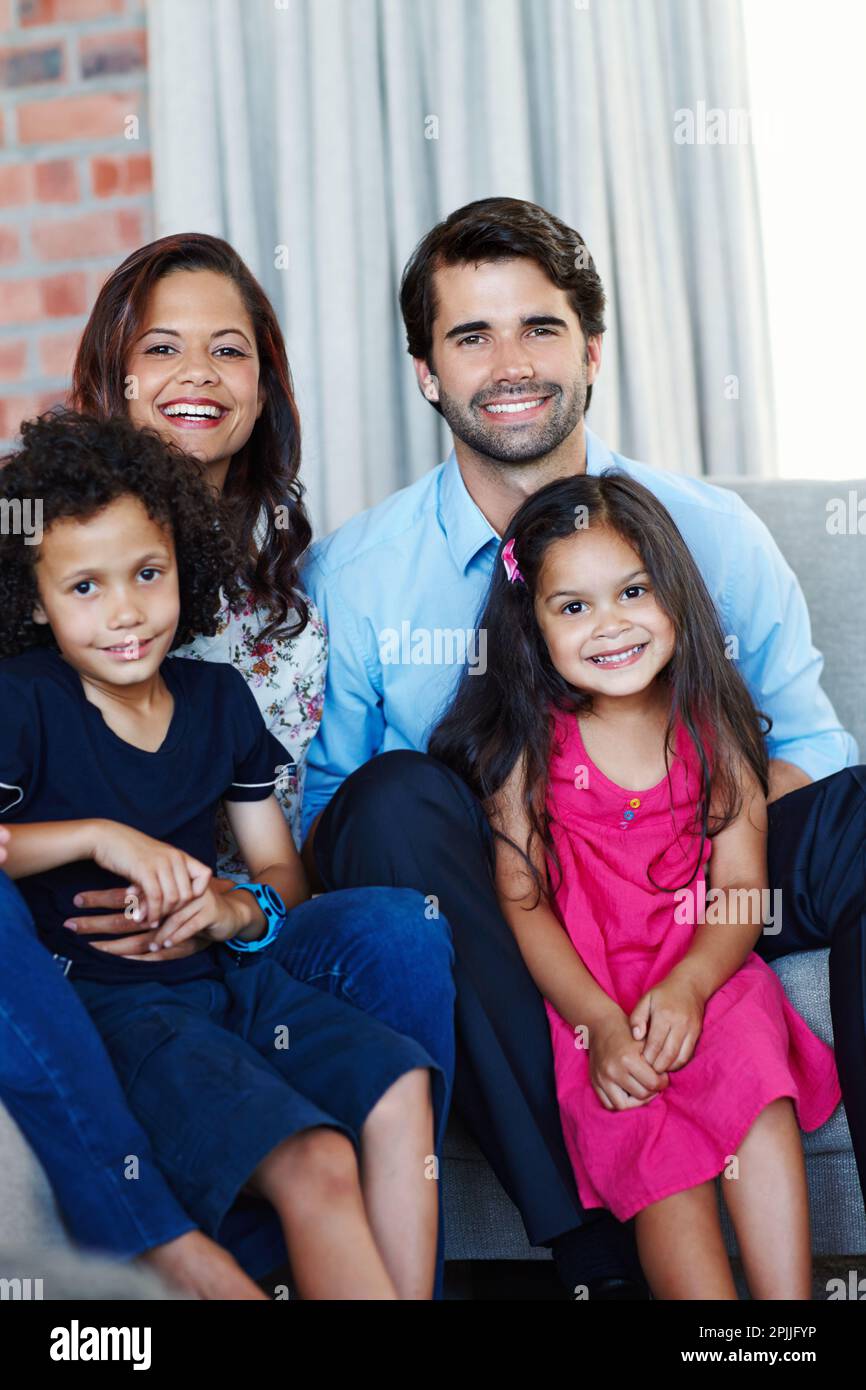 Family comes first. Portrait image of an adorable family sitting on the ...