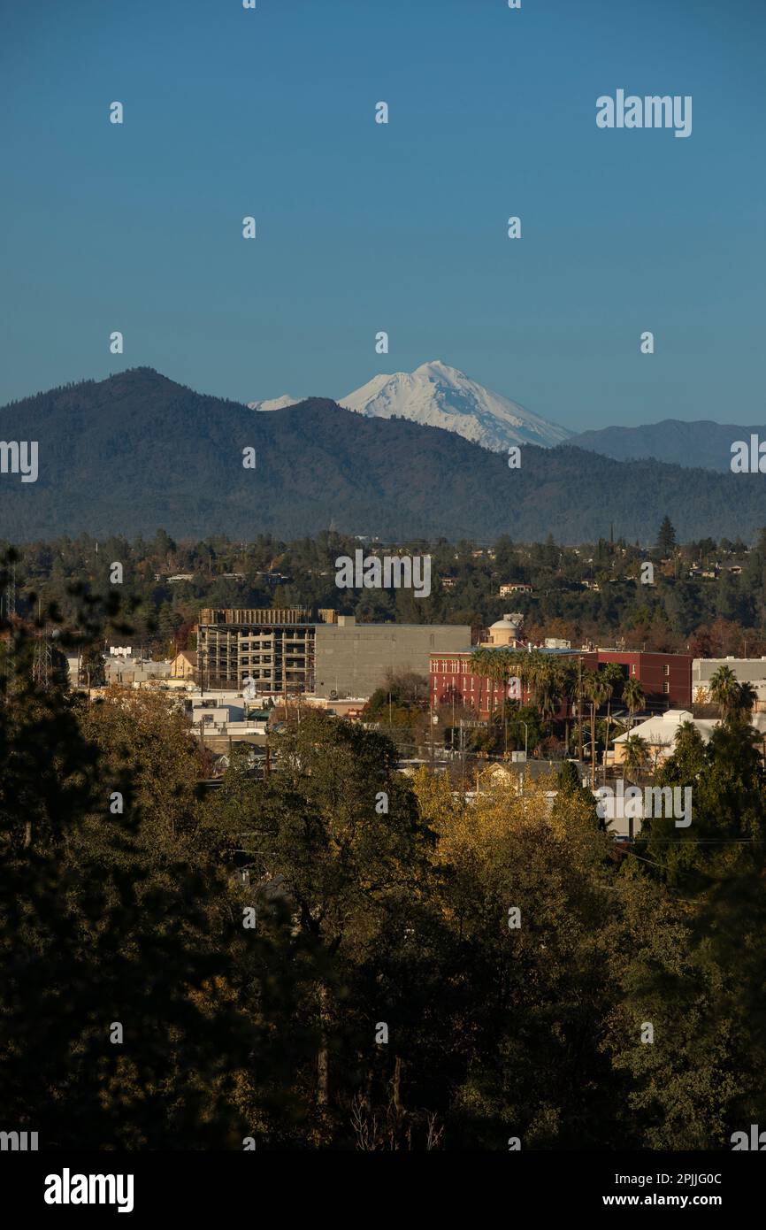 Afternoon snow covered view of the peak of Mount Shasta and the downtown skyline of Redding ...