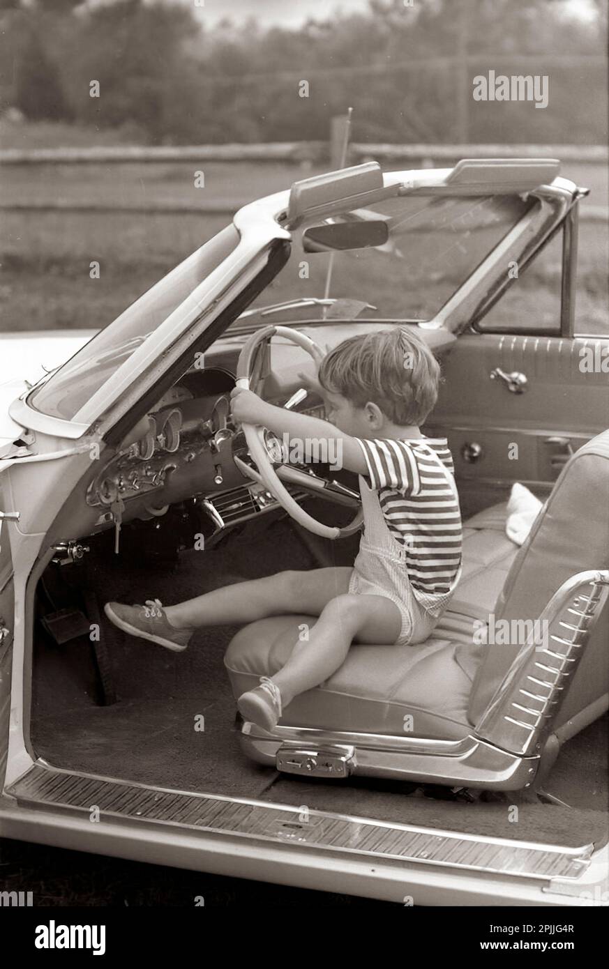 ST-C283-34-63 31 August 1963 John F. Kennedy, Jr. sits behind the wheel ...