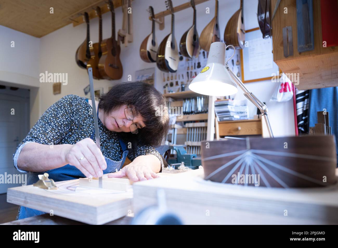Markneukirchen, Germany. 23rd Feb, 2023. Brunhilde Jacob, mandolin maker, works on a mandolin in ...