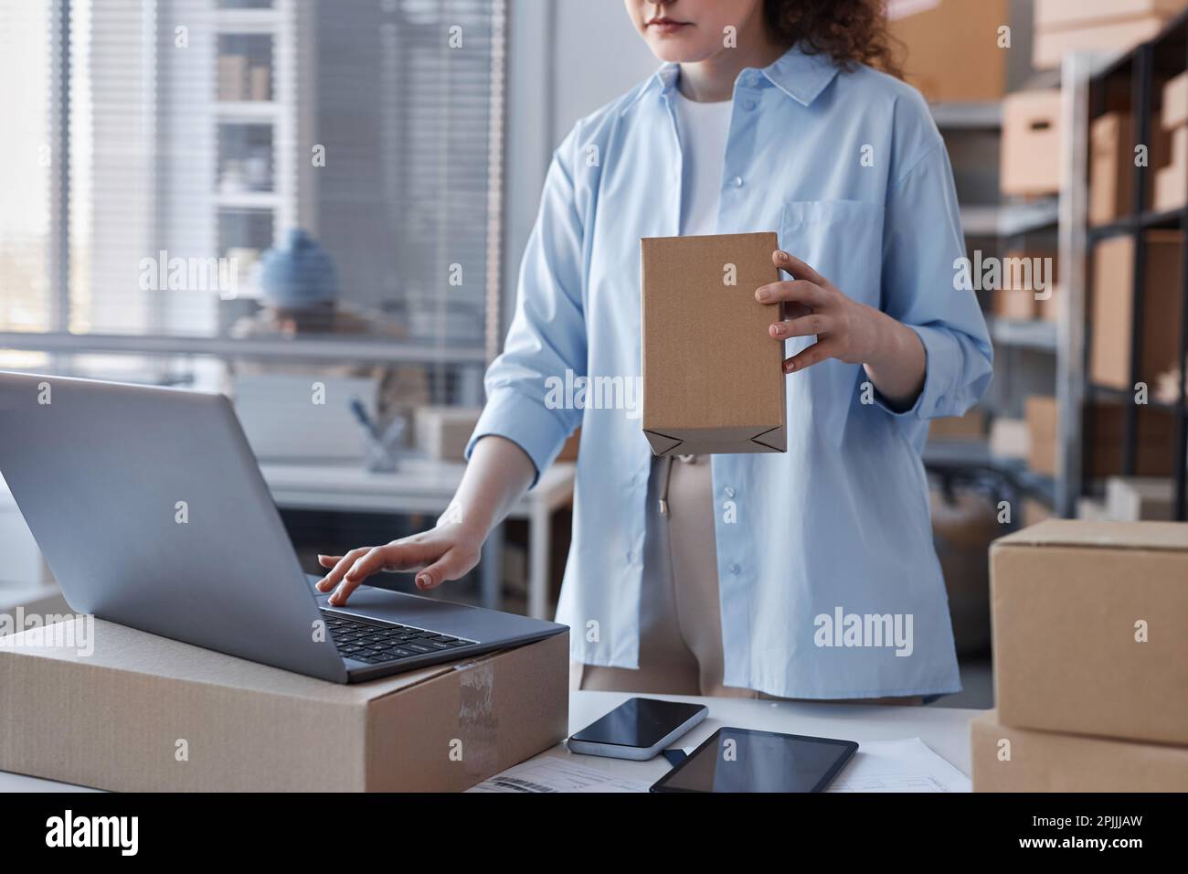 Cropped shot of young female worker of post office checking address of ...