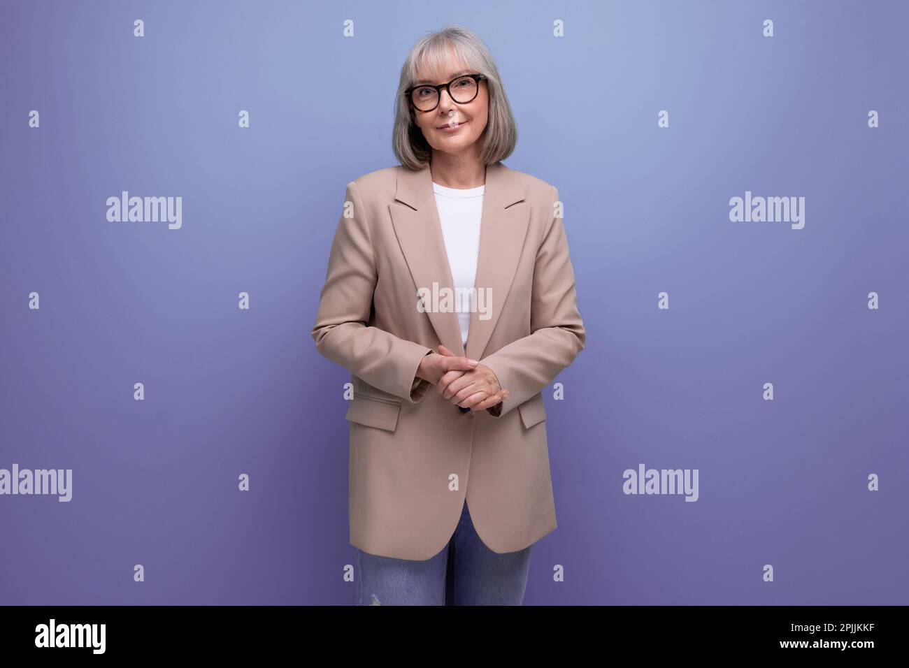 confident 60s middle aged woman in stylish look smiling against bright ...