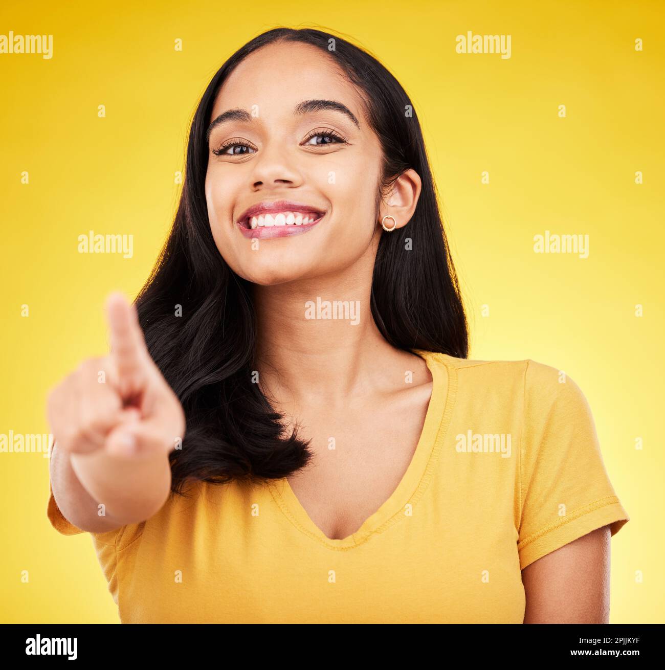 Pointing, happy and portrait of a woman in a studio with a smile and ...