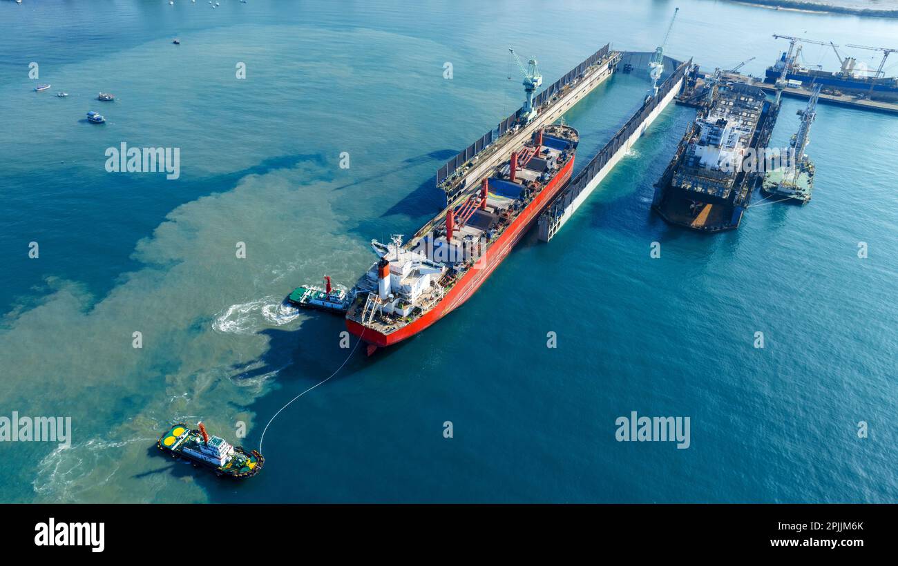 Tug boat Draging cargo container ship to dry dock concept maintenance ...