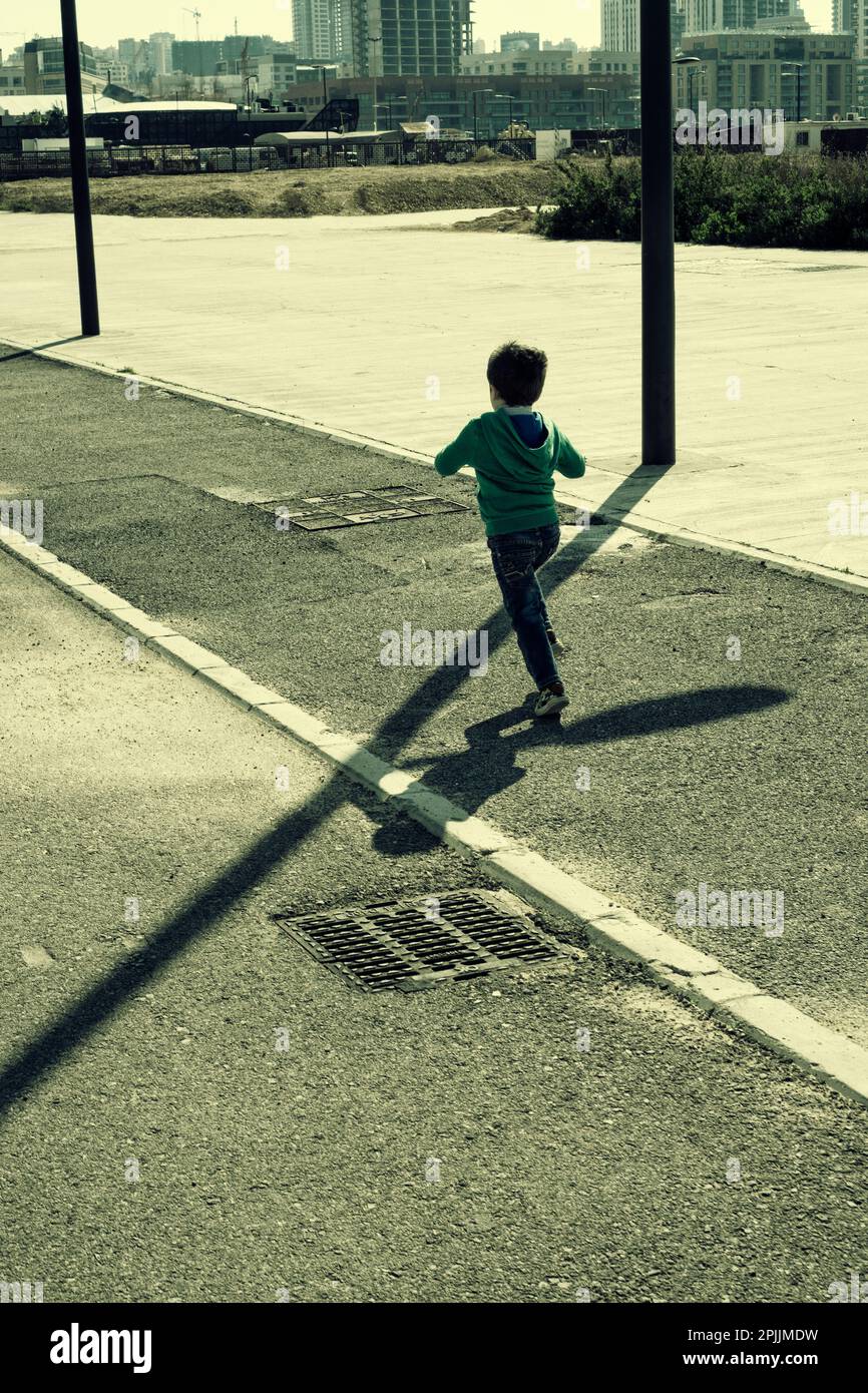Little boy running away in the street Stock Photo - Alamy