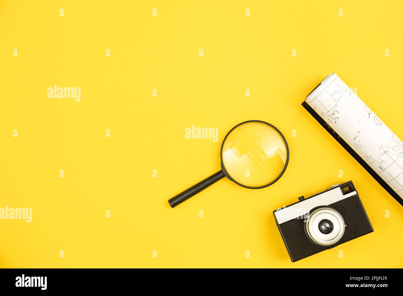 Magnifier, map and camera on yellow background, flat lay Stock Photo ...
