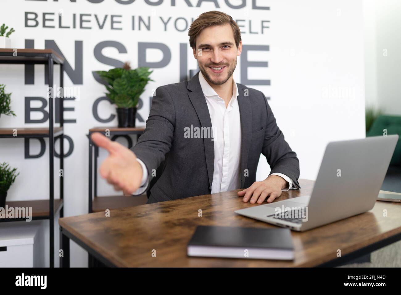 office worker stretches out his hand while sitting in the office at the ...
