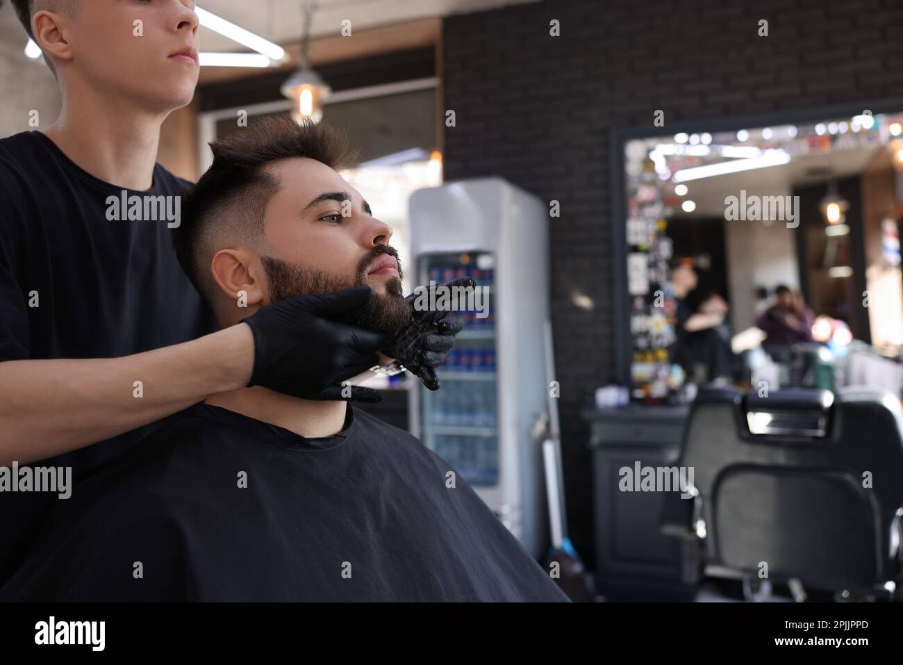 Professional hairdresser working with client in barbershop Stock Photo ...