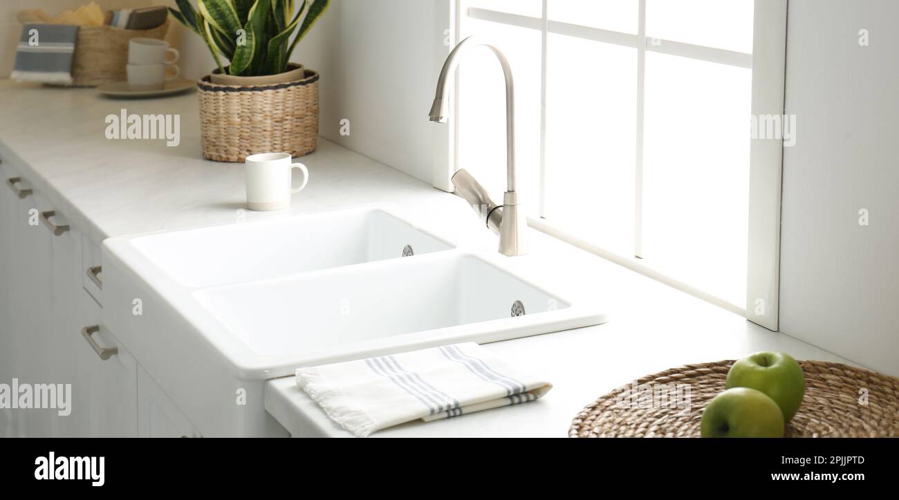 New ceramic sink and modern tap in stylish kitchen interior. Banner ...