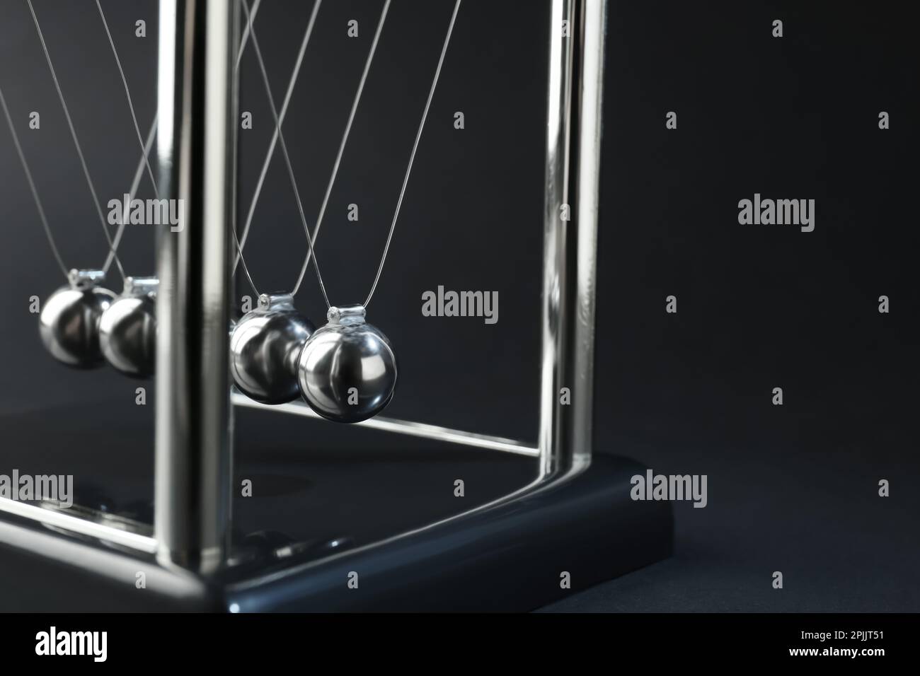 Newton's cradle on dark background, closeup. Physics law of energy ...