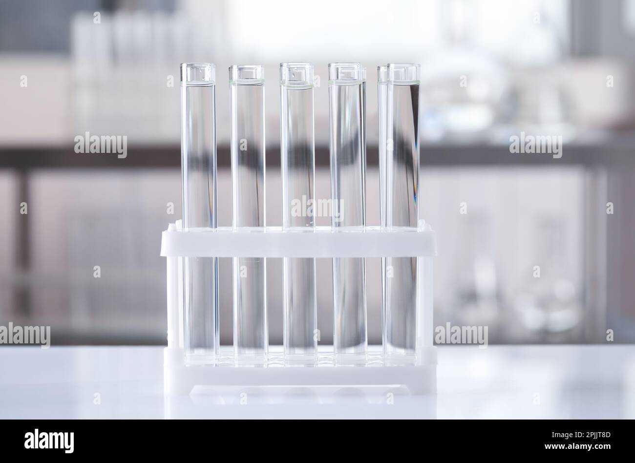 Test tubes with transparent liquid on table in laboratory Stock Photo ...