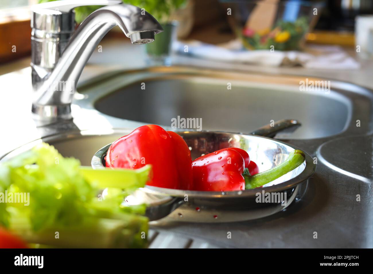 Colander with fresh bell peppers in kitchen sink Stock Photo - Alamy