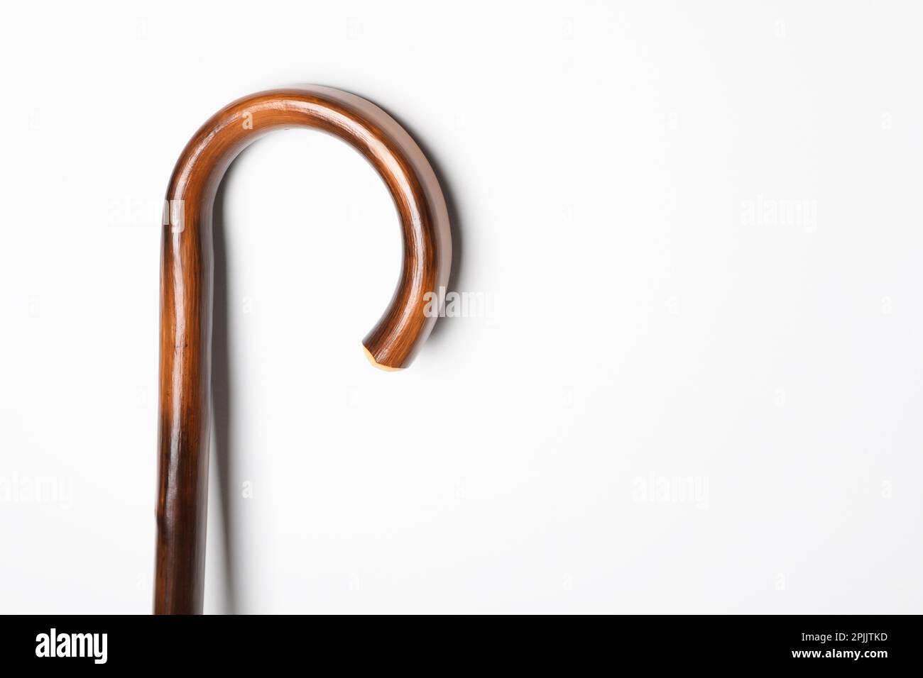 Elegant wooden walking cane on white background, closeup. Space for ...