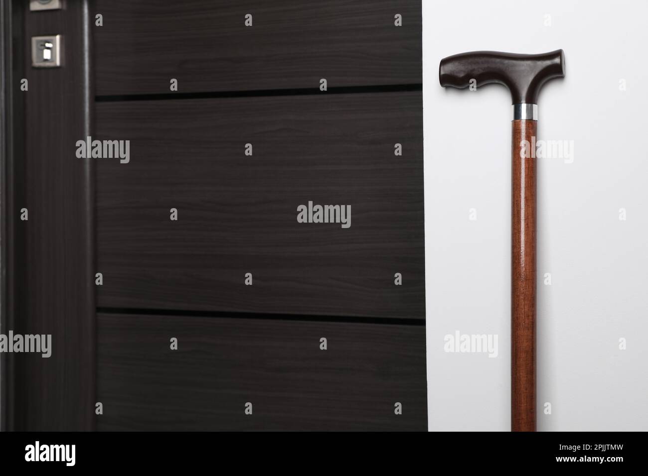 Elegant walking cane near door indoors, space for text Stock Photo - Alamy