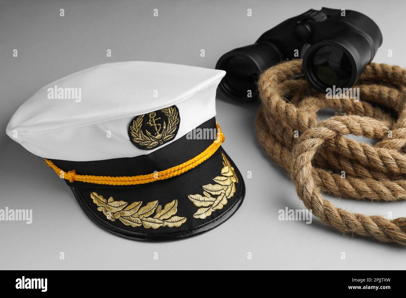 Peaked cap, rope and binoculars on light grey background Stock Photo ...