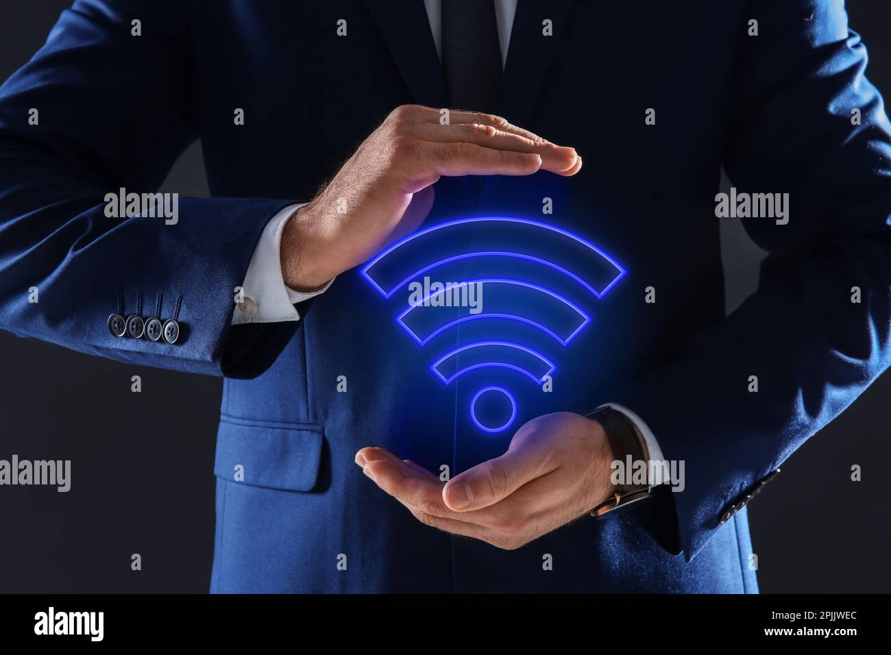 Man holding Wi Fi symbol in hands on dark grey background, closeup ...