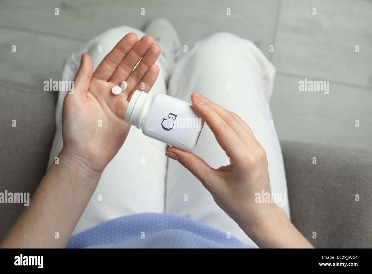 Calcium supplement. Woman taking pills indoors, top view Stock Photo ...
