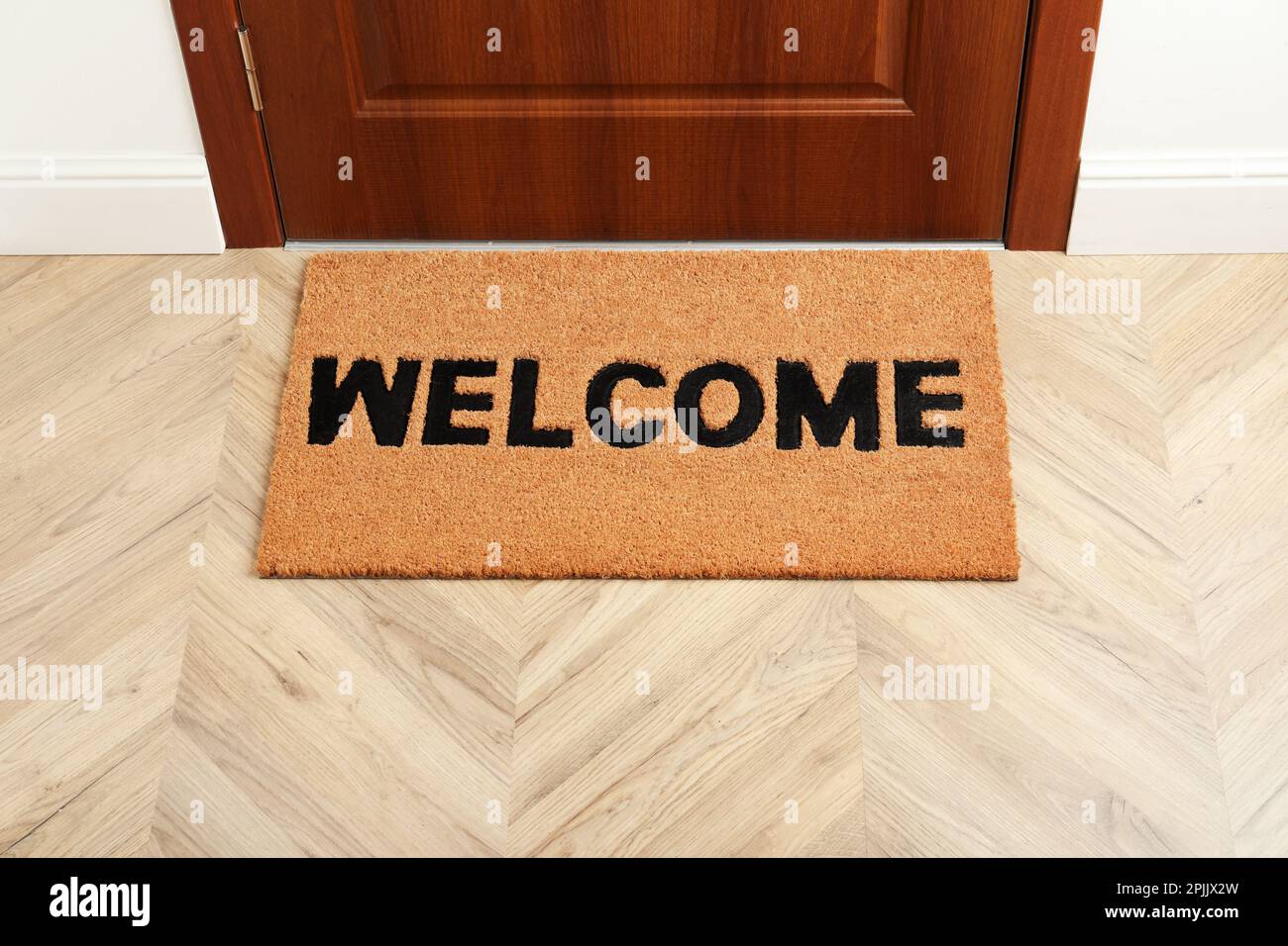 New clean brown mat with word Welcome near entrance door Stock Photo ...