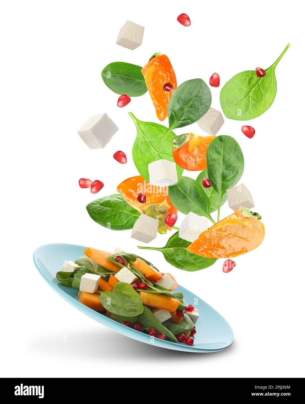 Tasty ingredients for persimmon salad falling into plate on white ...