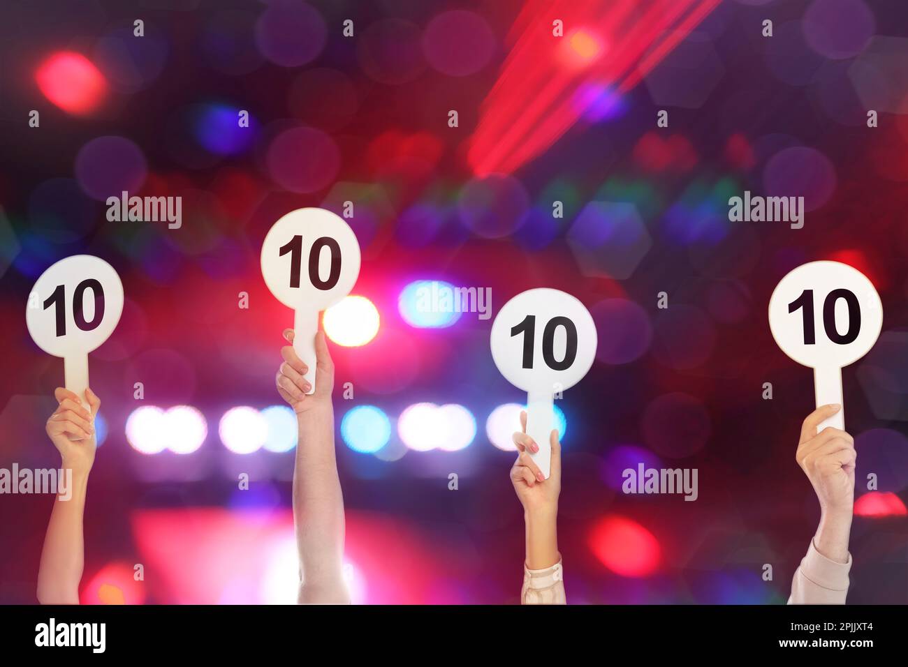 Panel of judges holding signs with highest score against blurred ...
