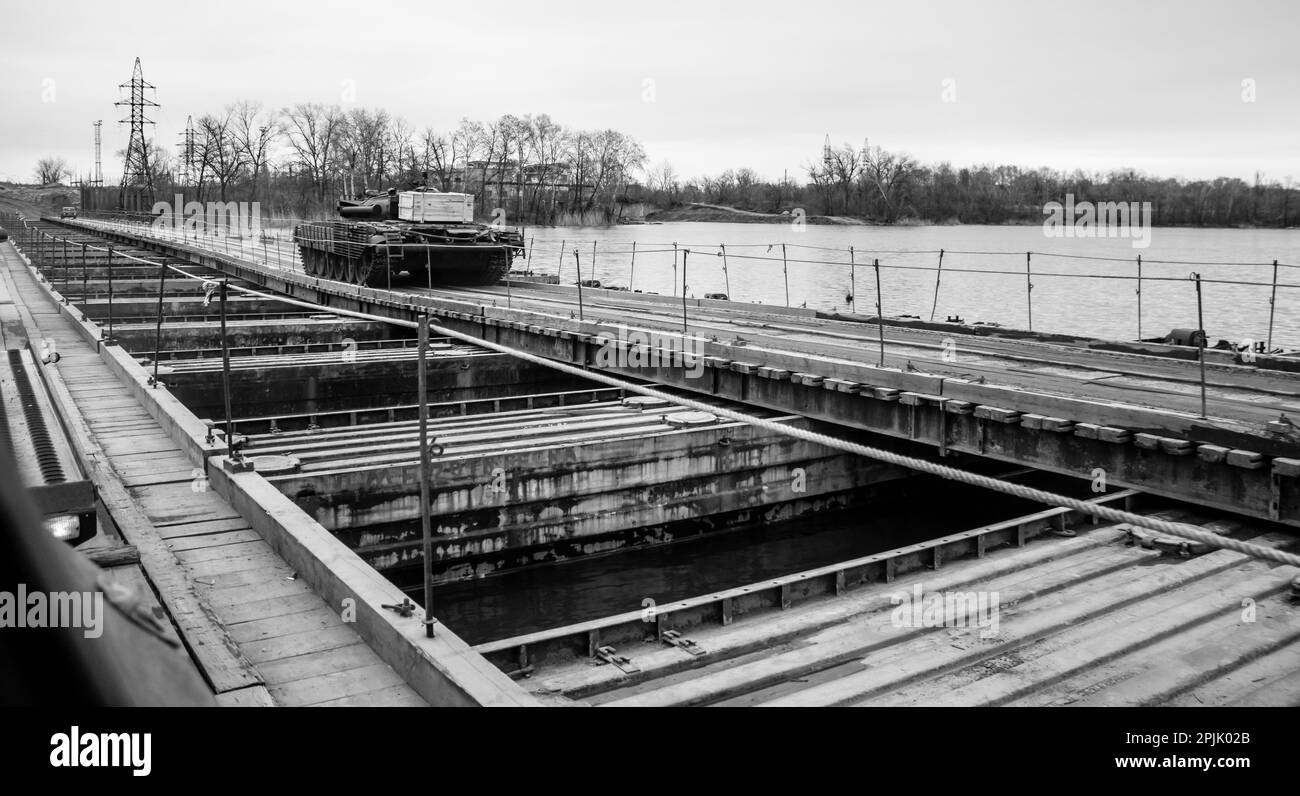 Ukrainian T-72B tank crossing a pontoon bridge rising to the front line ...