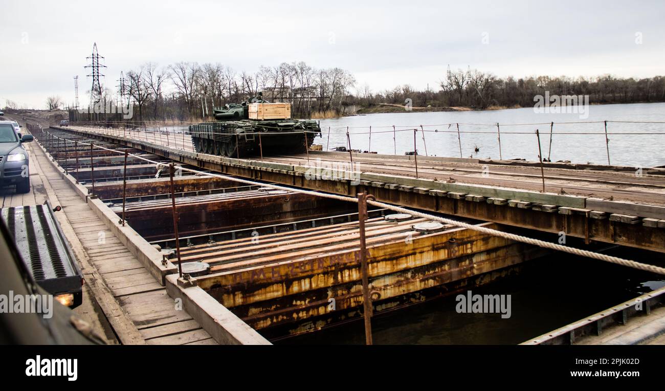 Ukrainian T-72B tank crossing a pontoon bridge rising to the front line ...
